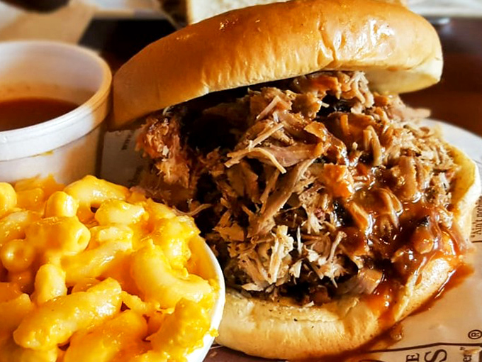 A sandwich that requires both hands and several napkins—as nature intended. The pulled pork spills generously from its bun, a testament to Dreamland's no-skimping philosophy.