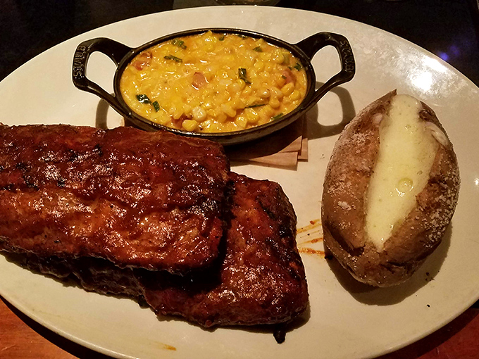 Baby back ribs with a glaze so shiny you could check your reflection before diving in. The loaded baked potato stands by, ready for its supporting role.