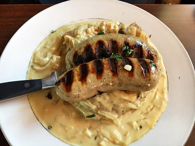 These bangers and mash aren't just comfort food; they're a hug on a plate, with sausages grilled to perfection atop creamy mashed potatoes.
