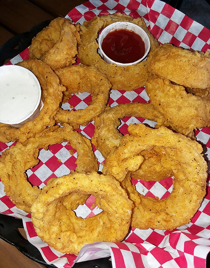 Golden-brown onion rings stacked like delicious life preservers in a sea of flavor. These aren't just side dishes—they're supporting actors stealing the show.