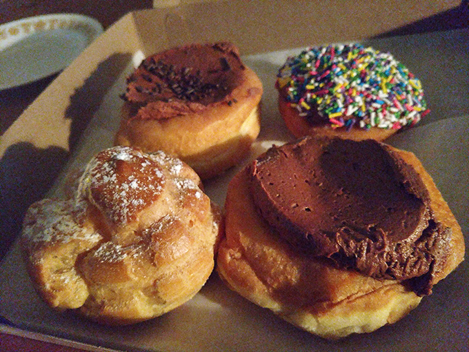 A quartet of donuts showing off their personalities: powdered, chocolate-topped, sprinkled, and cream-filled&mdash;the Fab Four of the pastry world.