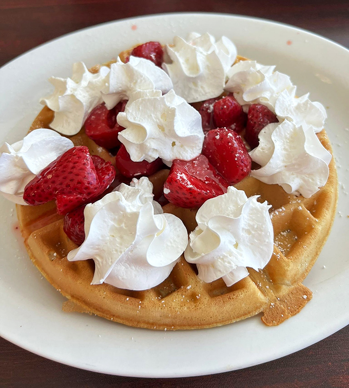 Strawberries and whipped cream transform an ordinary waffle into something worth driving across county lines for—crisp outside, cloud-like inside.