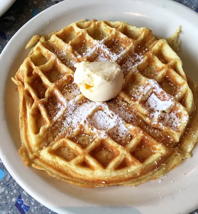 This Belgian waffle isn't just breakfast&mdash;it's architecture. Perfectly formed squares cradle butter and powdered sugar in a morning masterpiece worth waking up for.