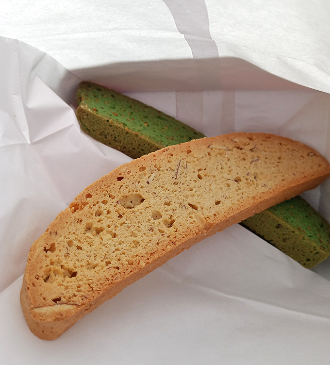 Traditional biscotti&mdash;one beige, one green&mdash;waiting to be dunked. These twice-baked treasures are the perfect coffee's companion for thoughtful conversations.