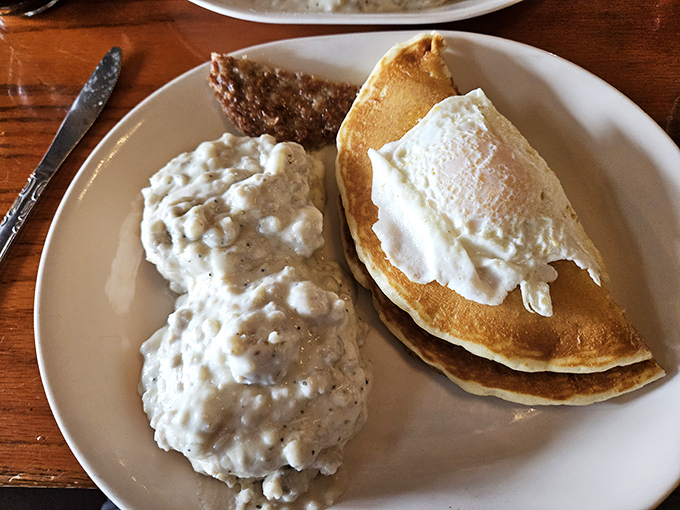 Biscuits smothered in country gravy alongside golden pancakes. The kind of plate that makes you want to call your cardiologist just to brag.