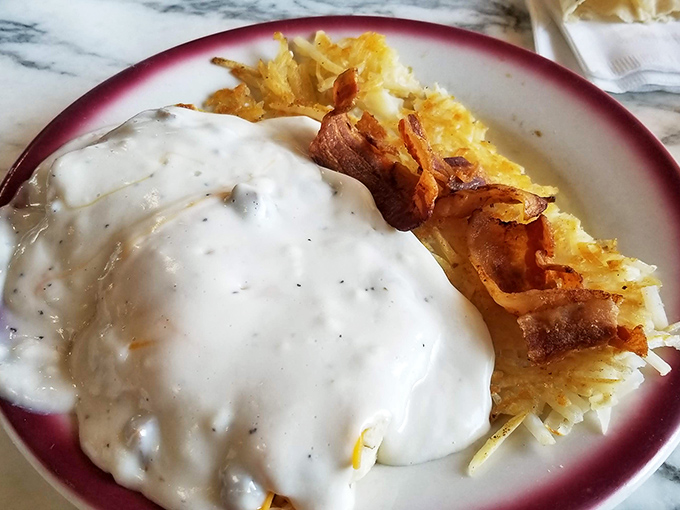 Gravity-defying gravy blankets crispy hash browns like a warm hug for your taste buds. Breakfast architecture at its most delicious.