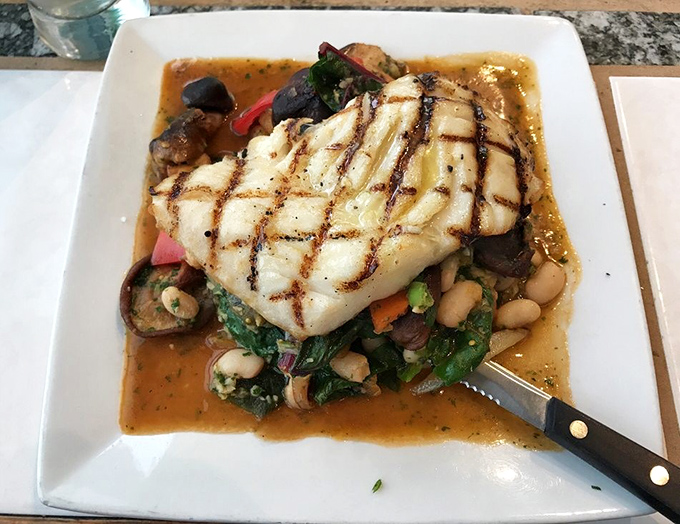 Perfectly grilled black cod rests atop a vibrant medley of vegetables. The crosshatch grill marks aren't just for show&mdash;they're flavor's signature.