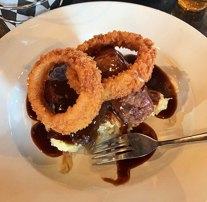 Braised beef so tender it practically surrenders to your fork, accompanied by onion rings that deserve their own fan club.