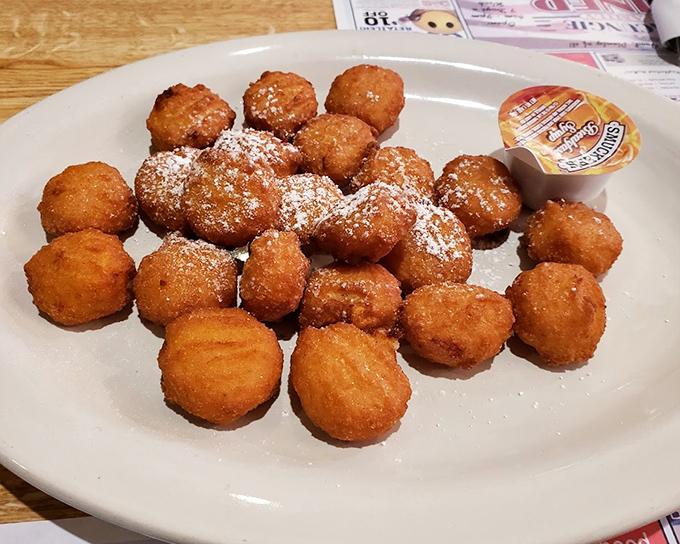 Golden-fried perfection in bite-sized form. These aren't just any hush puppies—they're little orbs of happiness dusted with powdered sugar, waiting to make your day better.