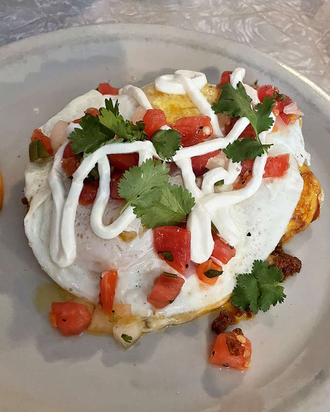 These breakfast enchiladas aren't just topped with an egg—they're crowned with one. The sour cream drizzle and fresh cilantro are the jewelry.