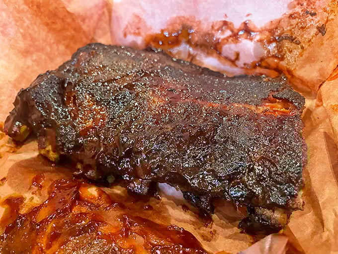 The brisket's bark is like nature's candy—a peppery, smoky crust protecting meat so tender it practically surrenders at the sight of a fork.