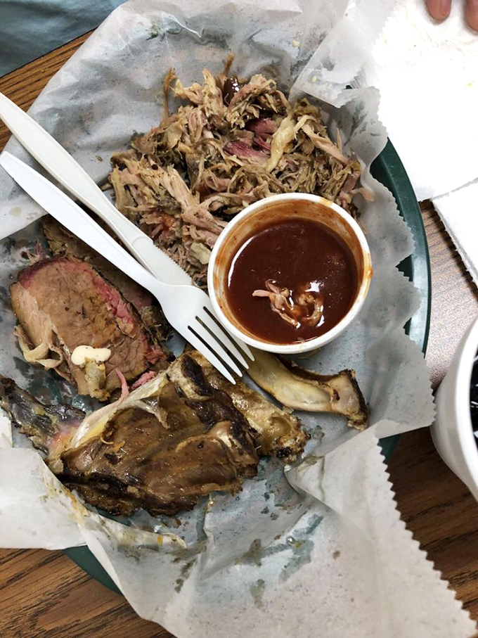 The barbecue trinity&mdash;brisket, pulled pork, and ribs&mdash;arranged on butcher paper like the culinary equivalent of a Renaissance painting.