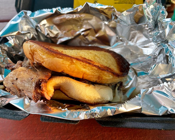 This brisket sandwich towers like a delicious skyscraper, demanding both hands and complete attention to navigate.