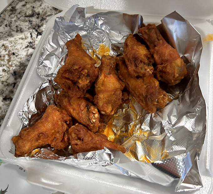 Wing perfection doesn't need fancy presentation. These golden-fried beauties glisten with sauce, promising that perfect balance of crispy exterior and juicy interior.