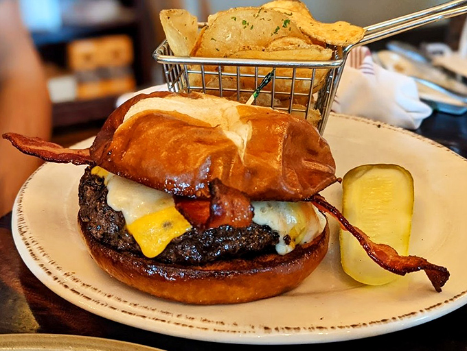 A burger that requires both hands and a strategy&mdash;crispy bacon hanging off the edges like it's making a break for freedom.