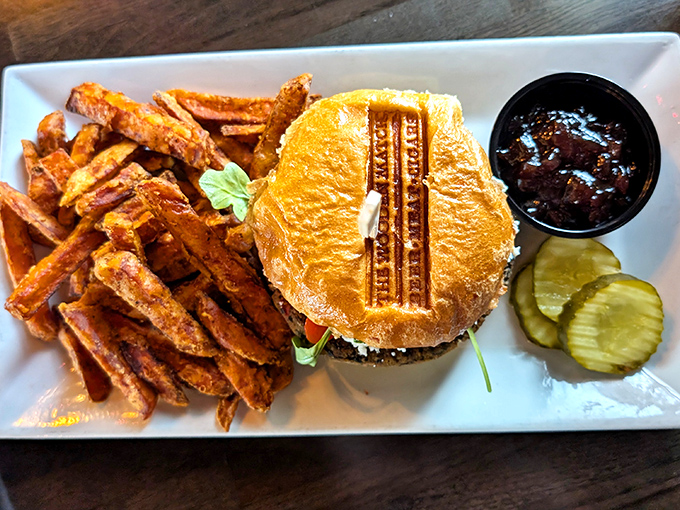 The burger arrives with grill marks so perfect they could win a geometry award. The sweet potato fries? Pure orange gold.