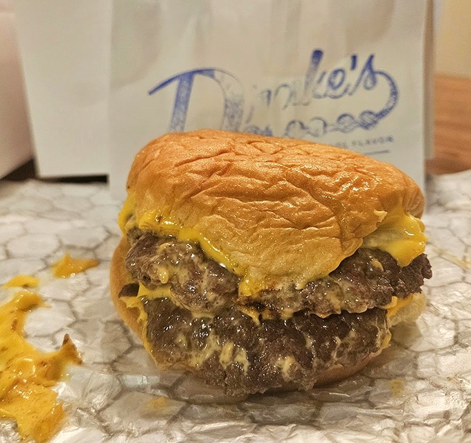 Behold the double cheeseburger in its natural habitat. Two beef patties melting into American cheese on a potato bun &ndash; comfort food that speaks a universal language.