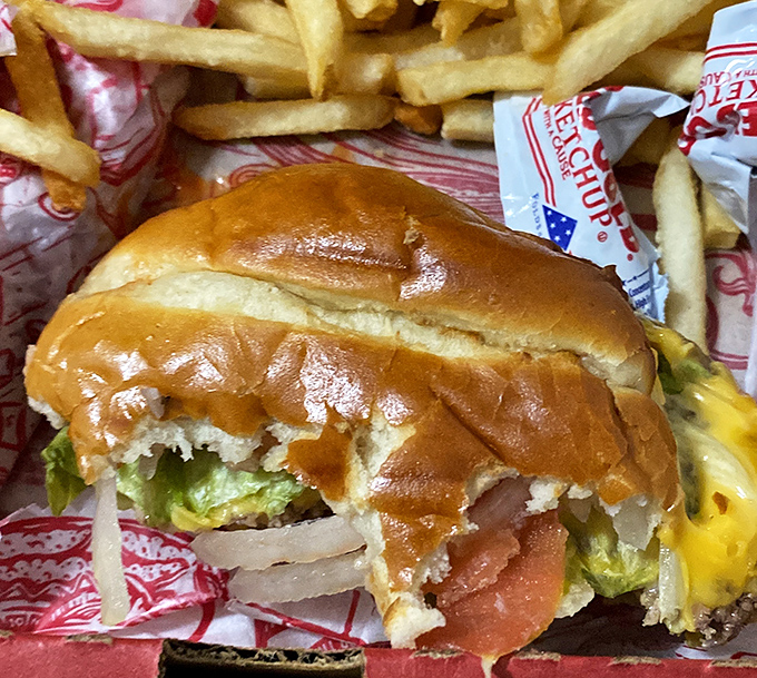 This isn't just a cheeseburger; it's architectural achievement with layers of flavor stacked between a perfectly toasted bun, surrounded by golden fries.