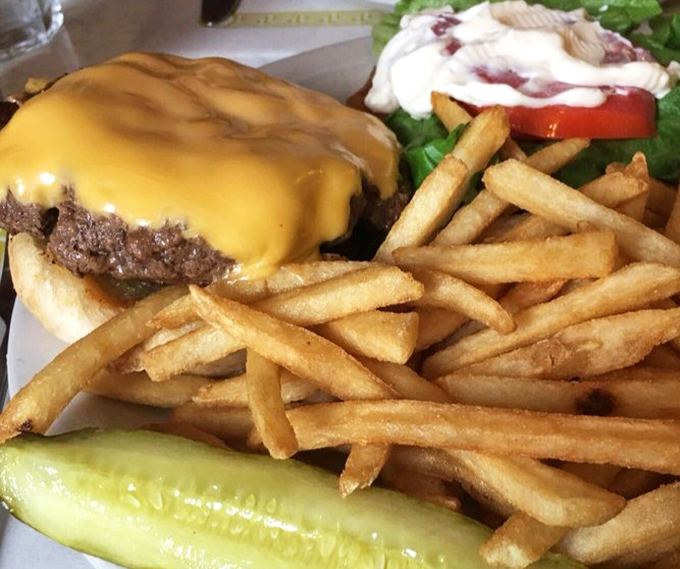 A proper diner cheeseburger doesn't need fancy aioli or artisanal buns – just honest beef, melty cheese, and a pickle spear saluting you.
