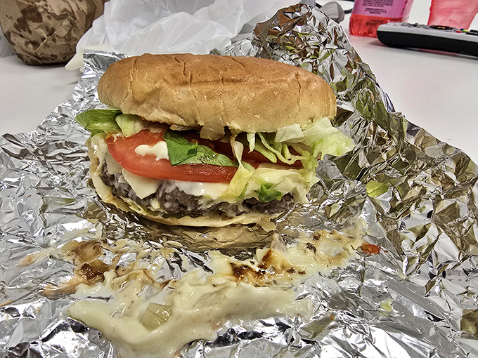 Behold the cheeseburger in its foil-wrapped glory. Melty cheese cascades down the patty like a dairy waterfall of deliciousness.