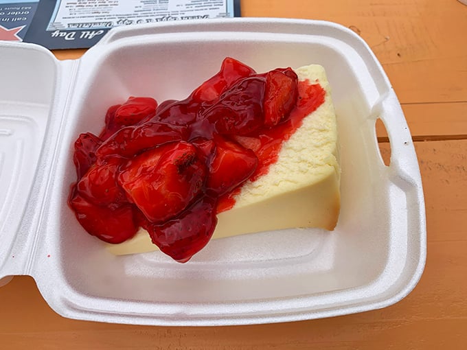Cheesecake topped with strawberry compote &ndash; where dense, creamy decadence meets sweet-tart fruit in a styrofoam container of pure joy.