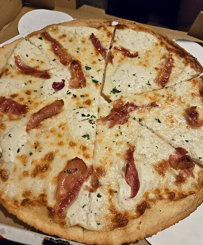 White pizza with bacon that would make even the most dedicated cardiologist take a cheat day. Worth every delicious calorie.