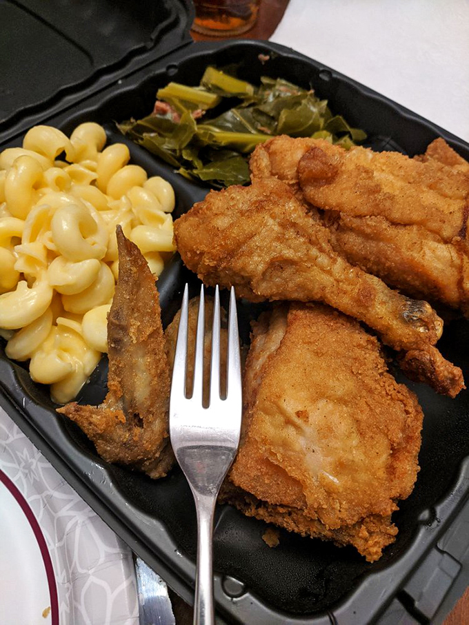 Golden-brown perfection meets fork-tender chicken in this dinner plate, flanked by mac and cheese and greens that aren't just obligatory afterthoughts.