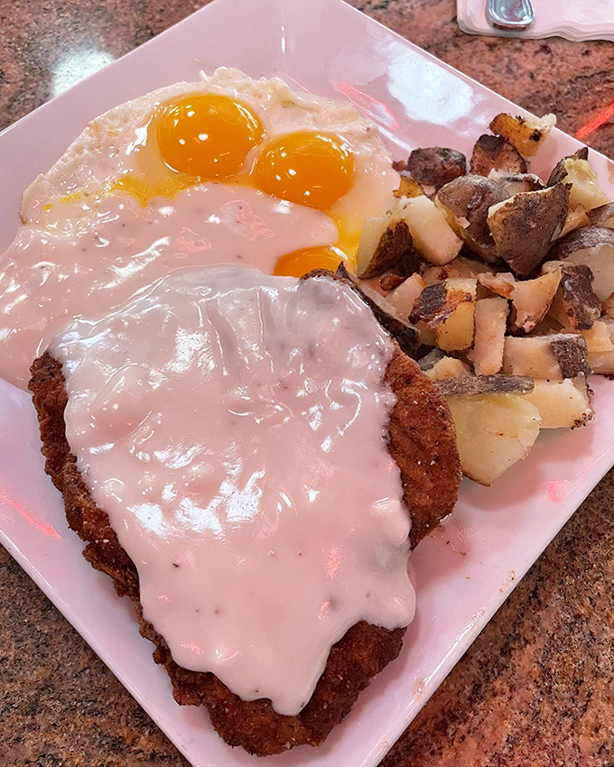 Country-fried steak smothered in gravy alongside sunny-side-up eggs—the breakfast equivalent of a warm hug from your favorite aunt.