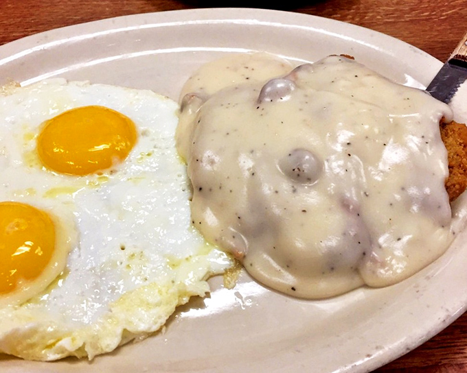 Chicken fried steak smothered in gravy alongside sunny-side-up eggs. This plate doesn't just feed you&mdash;it hugs your soul on a cellular level.