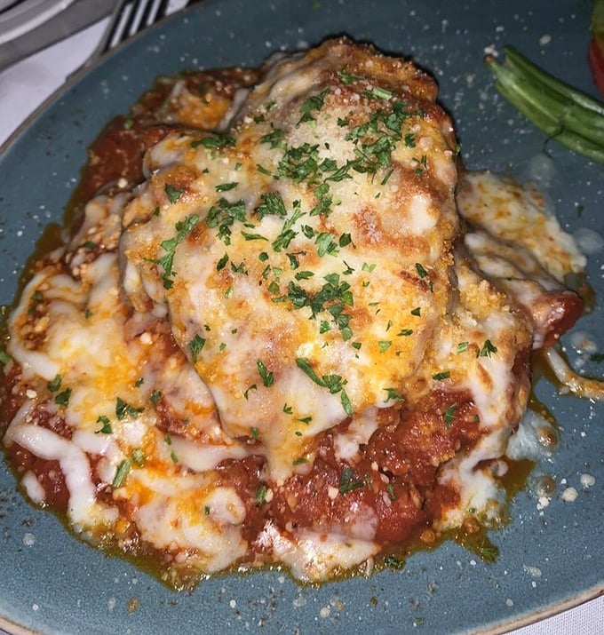 Chicken Parmesan that's dressed better than most wedding guests &ndash; a golden-crusted masterpiece swimming in marinara and melted cheese.