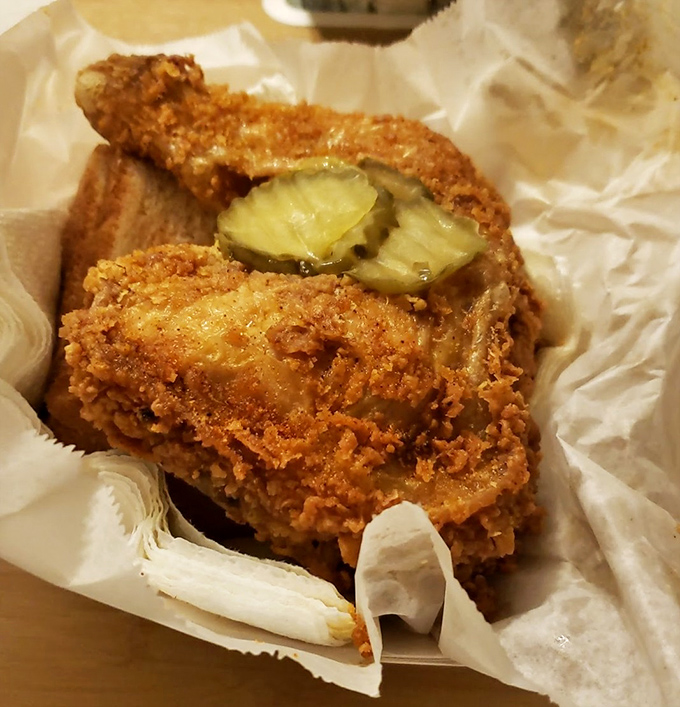 Golden-fried perfection with pickle chips standing guard. This isn't just chicken&mdash;it's Nashville's culinary legacy wrapped in crispy, spice-laden armor.