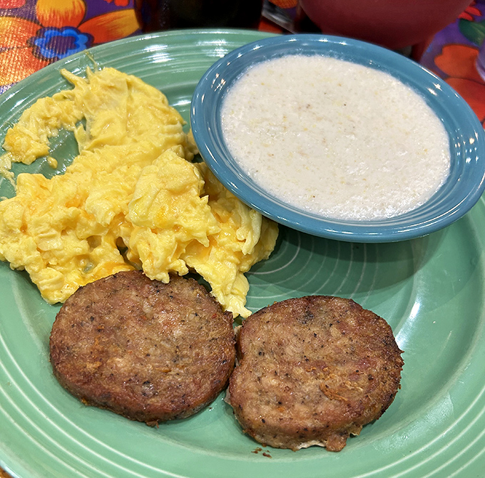 Breakfast's holy trinity: fluffy scrambled eggs, savory sausage patties, and creamy grits&mdash;a Southern morning ritual worth setting an alarm for.