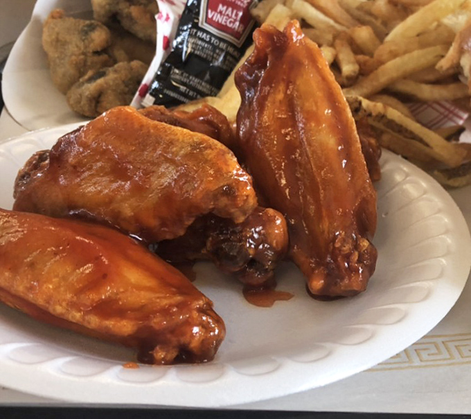 Wings glistening with sauce that means business. The kind that make you forget about napkins until it's way too late.