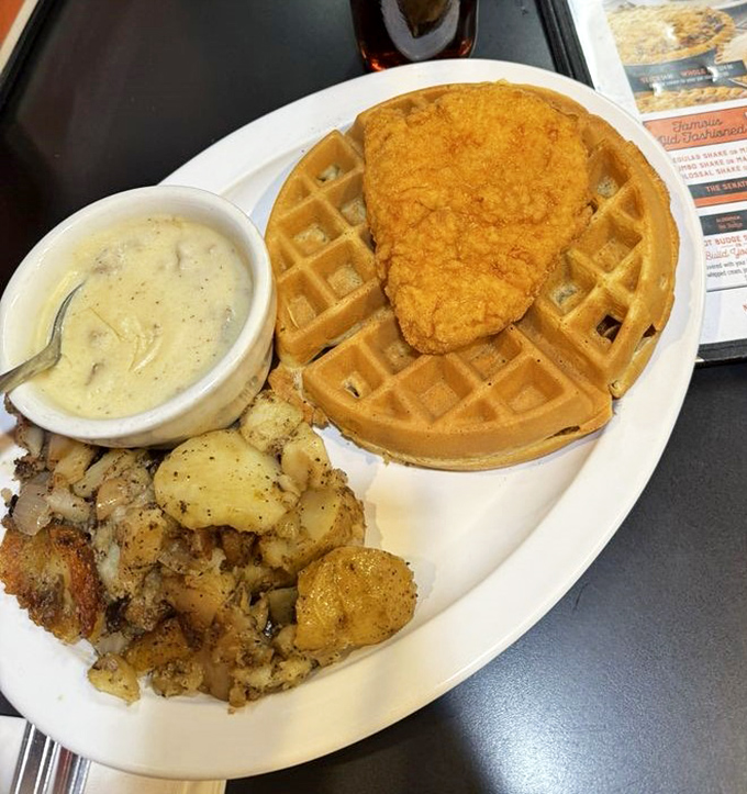 Southern comfort meets breakfast rebellion: crispy chicken perched atop a golden waffle with gravy that could make your cardiologist weep.
