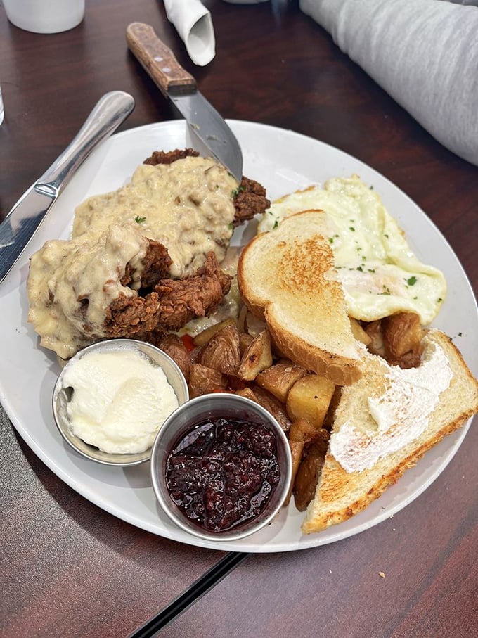 Country breakfast perfection: Chicken fried steak smothered in gravy with eggs and home fries. Comfort food that hugs your soul.