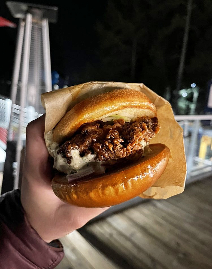 This isn't just a chicken sandwich&mdash;it's architecture. The golden bun barely containing that crispy, sauce-glazed masterpiece deserves its own blueprint. 