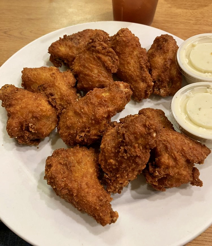 Golden-brown chicken wings that crunch like autumn leaves, served with dipping sauces that make sharing an act of true friendship or terrible strategy.