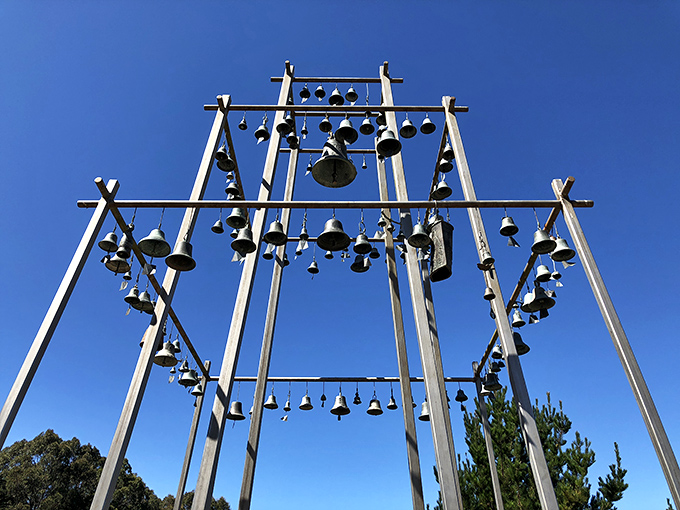 The Children's Bell Tower stands sentinel against blue skies. Each bell carries its own story, creating a hauntingly beautiful coastal landmark.