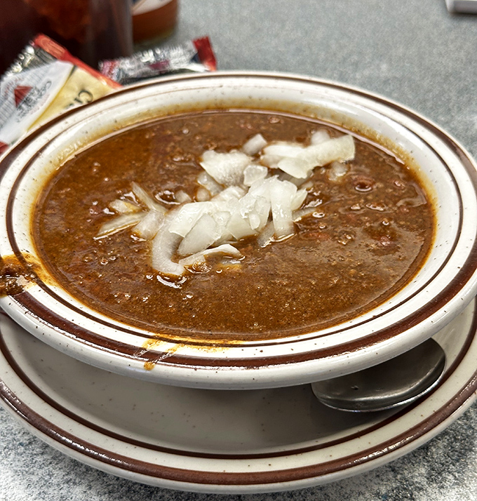 This isn't just chili—it's a warm hug in a bowl, topped with diced onions that add the perfect crunch to each spoonful.