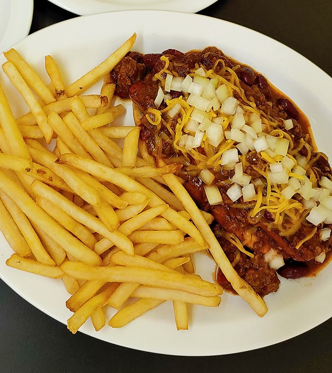 Chili that doesn't hide behind pretension, topped with diced onions and shredded cheese &ndash; comfort food that demands both napkins and respect.