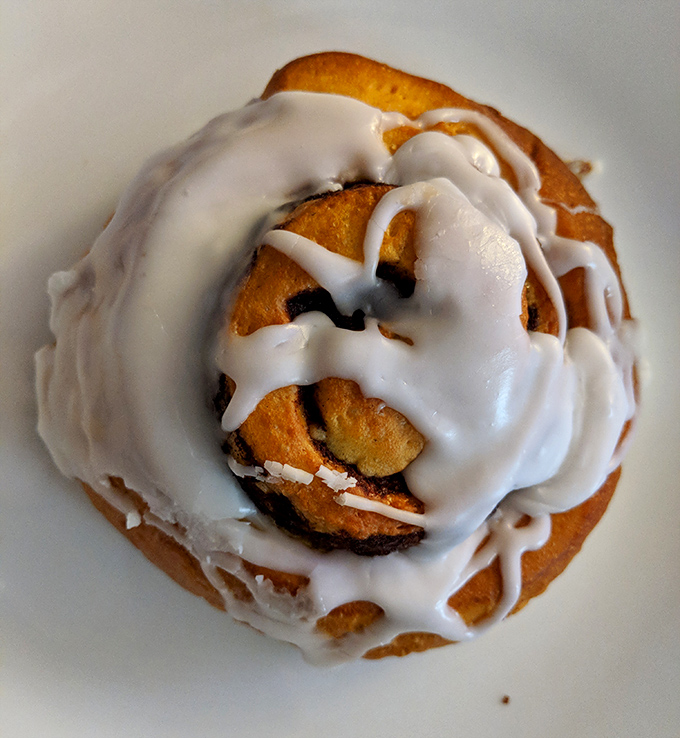 This isn't just a cinnamon roll—it's what happens when vanilla icing has a passionate love affair with freshly baked dough.