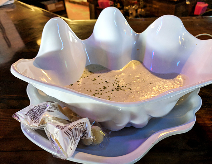 The clam chowder arrives in its own seashell throne, proving that presentation matters almost as much as that creamy, briny goodness.