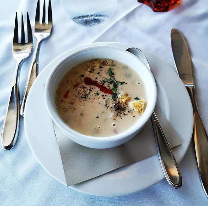 Creamy clam chowder arrives like a warm hug in a bowl, complete with perfectly placed garnishes and comfort.