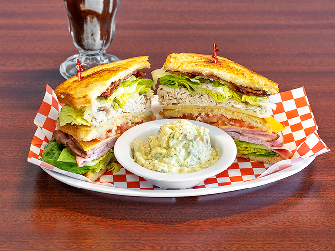 The club sandwich—architecture you can eat. Three stories of deliciousness held together with those little frilled toothpicks that somehow make everything taste better.