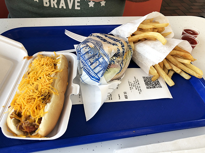 The holy trinity of American roadside cuisine: a chili-smothered coney, a perfectly wrapped burger, and fries that demand to be savored.
