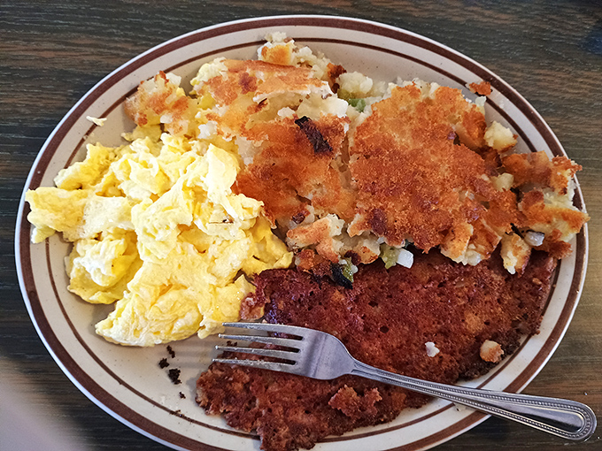 Breakfast trifecta perfection: fluffy scrambled eggs, crispy home fries, and country-fried steak with gravy that would make your grandmother nod in approval.