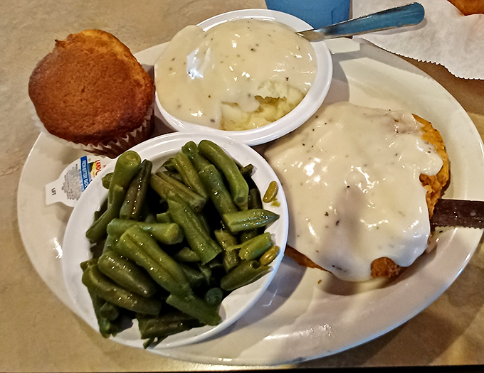 Country fried steak swimming in creamy gravy alongside green beans that actually taste like vegetables should.
