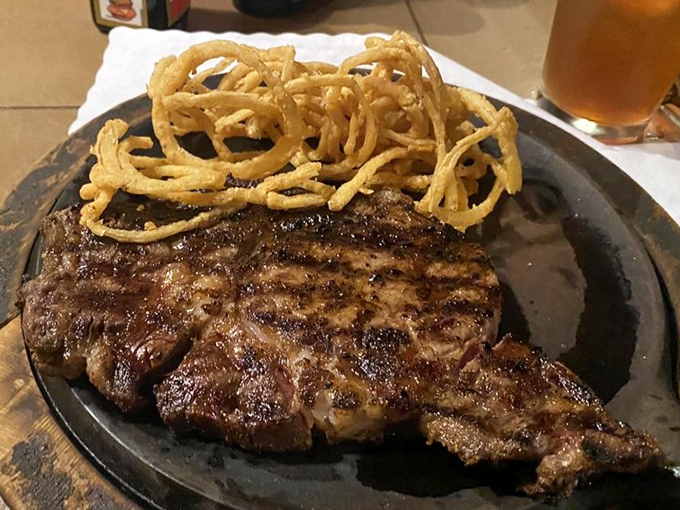 The cowboy steak arrives with its own posse of crispy onion strings. This isn't dinner; it's a showdown between your appetite and delicious destiny.