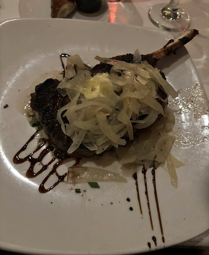 Meat masterpiece topped with caramelized onions that melt like butter. The artful sauce drizzle isn't just decoration&mdash;it's edible calligraphy.