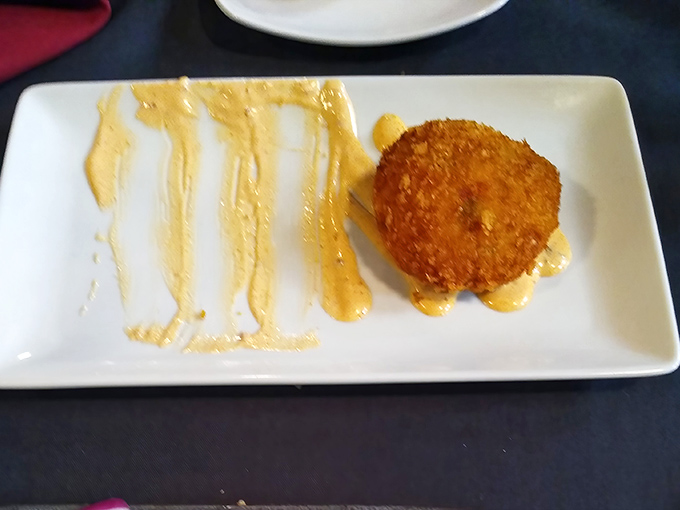 This golden-fried crab cake isn't just a dish—it's a statement. Crispy exterior, tender interior, and that remoulade sauce? Pure poetry on a plate.